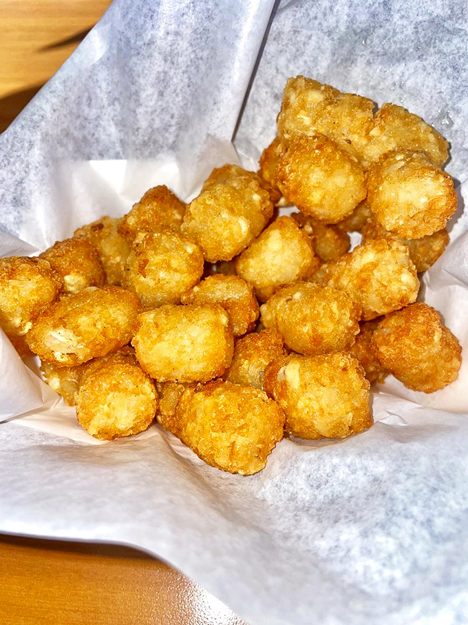 Golden-brown tater tots that crunch like autumn leaves, revealing cloud-like potato interiors that might just make you forget french fries ever existed.