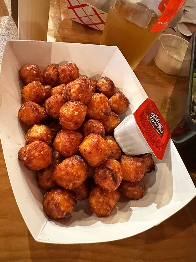 These aren't your cafeteria's tater tots. Golden-brown, perfectly seasoned, and piled high in their paper basket &ndash; they're what potato dreams are made of.