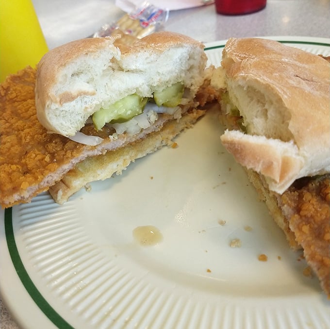 The legendary tenderloin sandwich in all its glory&mdash;golden-brown, crispy exterior extending well beyond its bun boundaries. This is sandwich architecture at its finest.