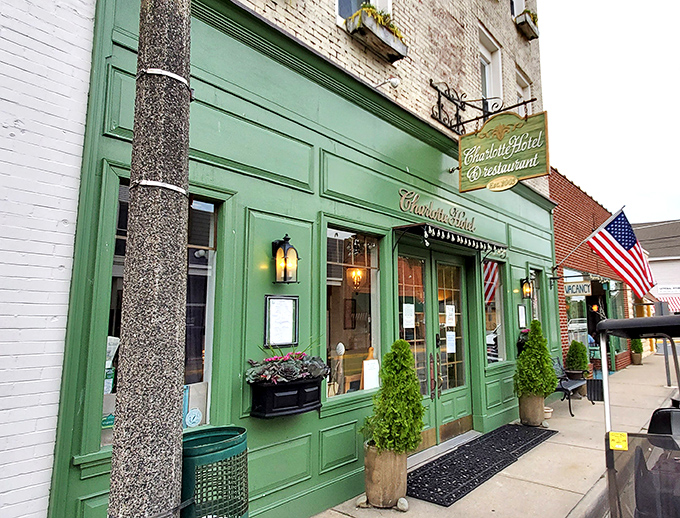 The Charlotte Hotel's emerald storefront glows with the kind of inviting warmth that makes you want to cancel your other plans and stay awhile.