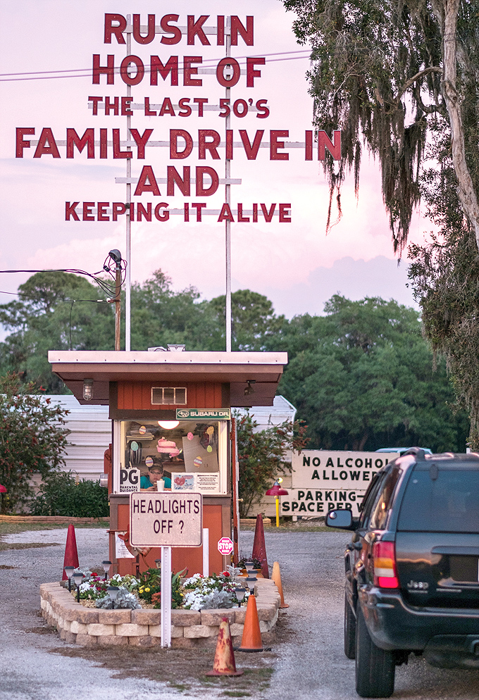 "Headlights off?" reminds the charming ticket booth. This small sentinel has greeted moviegoers for generations, surrounded by flowers and memories.