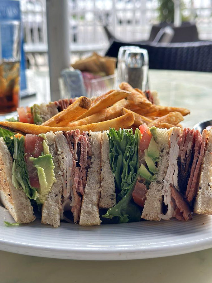 This isn't just a club sandwich&mdash;it's architecture. Three stories of perfectly stacked goodness that makes you wonder why skyscrapers aren't made of bacon and avocado.