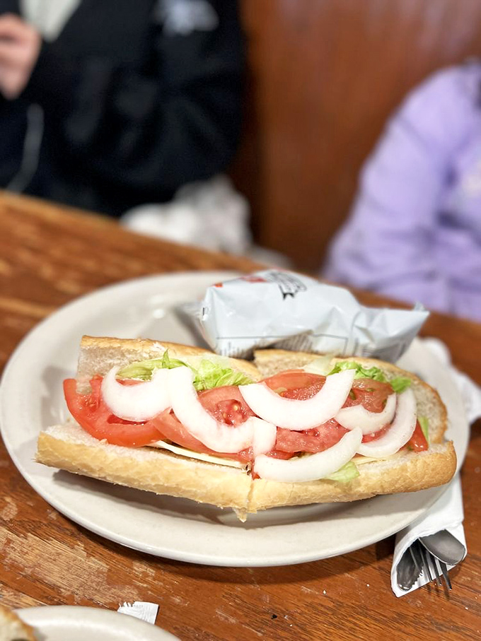 This isn't just a sandwich; it's a tomato and onion skyscraper that requires both hands, napkins, and possibly a building permit.