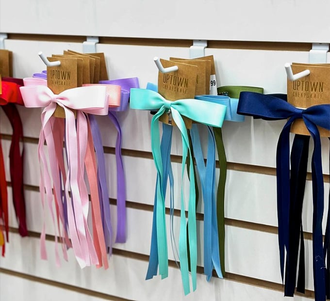A rainbow of ribbons adorns gift bags, proving that even the packaging at Uptown Cheapskate has style. Marie Kondo would approve of this organized joy.