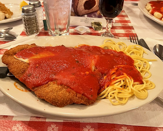 Behold the star attraction: golden-breaded veal blanketed in vibrant tomato sauce alongside perfectly twirled spaghetti. Resistance is futile.