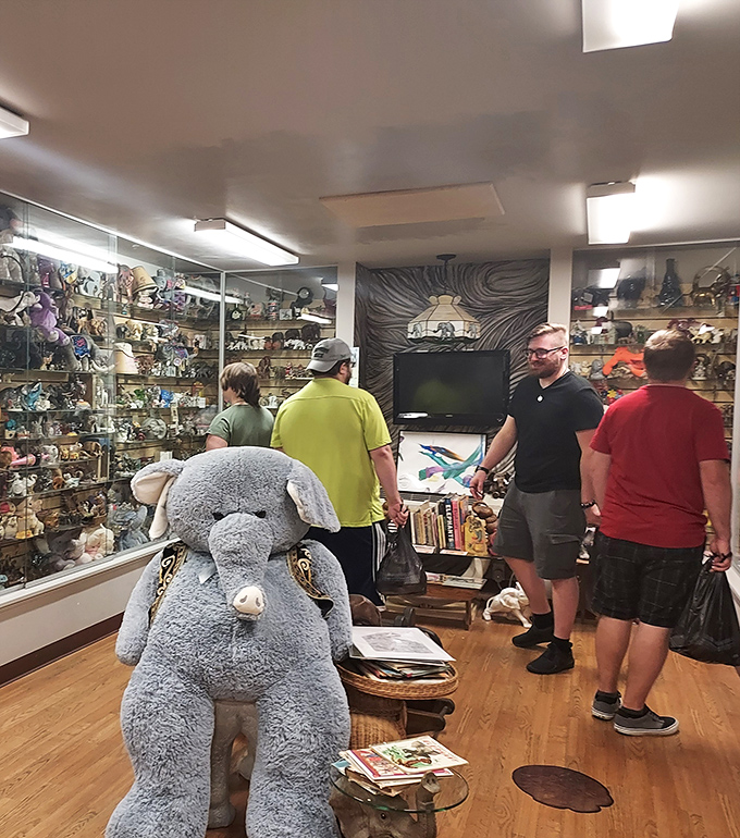 Visitors explore the museum's extensive collection while a plush elephant stands guard. Even stuffed pachyderms demand respect.