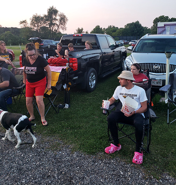 The blue concession building glows like a beacon as dusk settles in. Cinema's siren call of buttered popcorn and candy beckons from within.