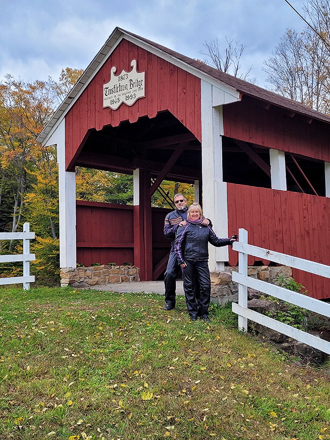 "Honey, we found it!" Visitors capture their moment with this historic landmark, proving that covered bridges make the perfect backdrop for memorable vacation photos.