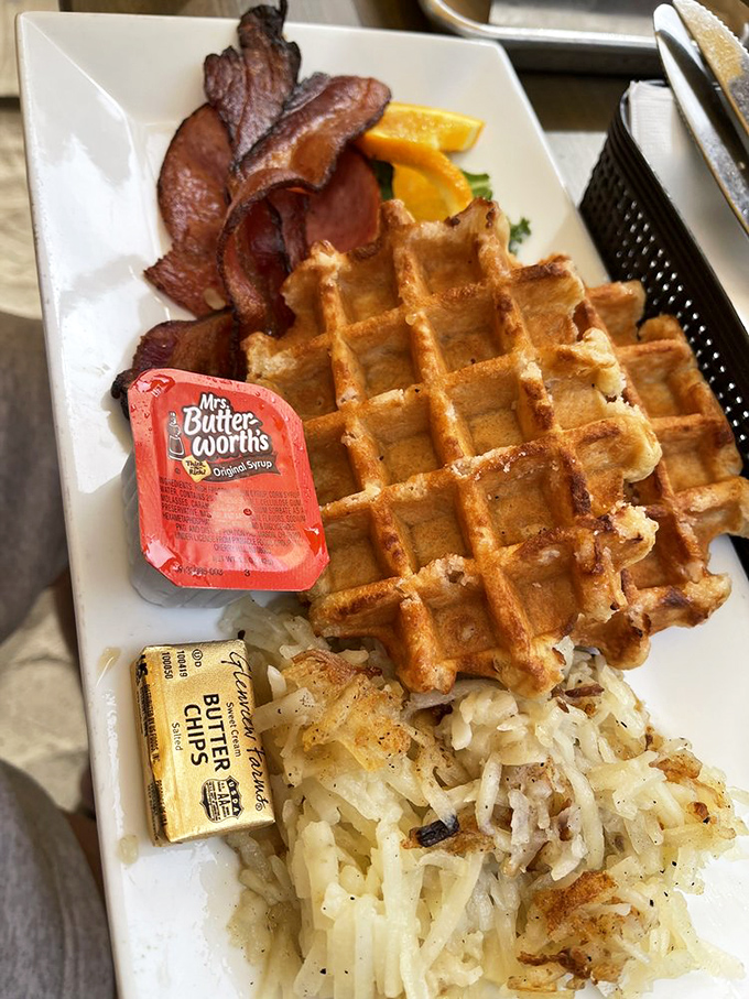 The legendary waffles arrive golden and crispy outside, cloud-soft inside&mdash;paired with perfectly crisped bacon and hash browns that would make your grandmother jealous.