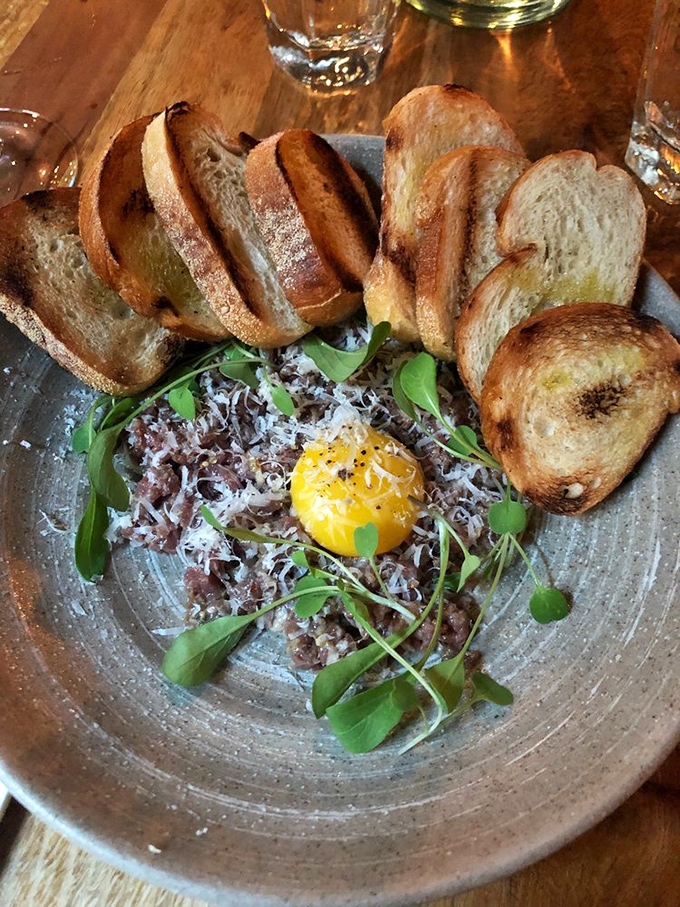 Wagyu beef tartare with a golden egg yolk crown. This isn't just dinner—it's edible artwork that makes you question why you ever cooked beef in the first place.