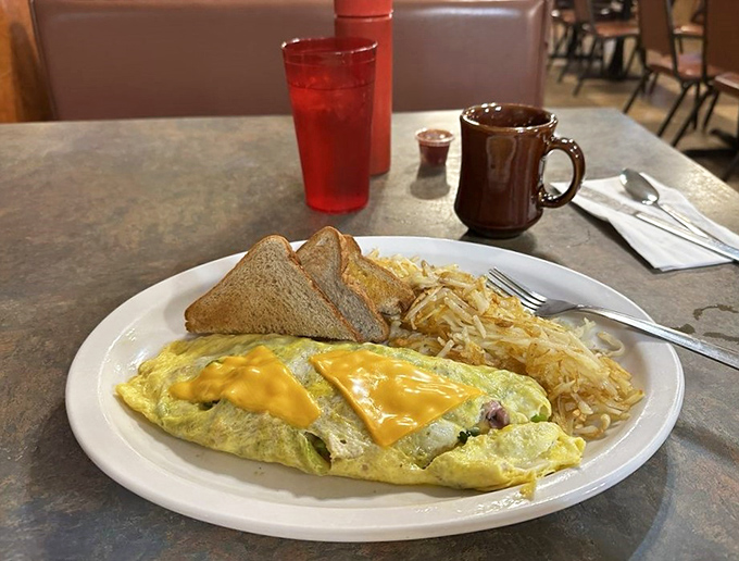 This Western omelet isn't trying to impress Instagram&mdash;it's too busy delivering cheese-draped satisfaction alongside a mountain of hash browns that means business.