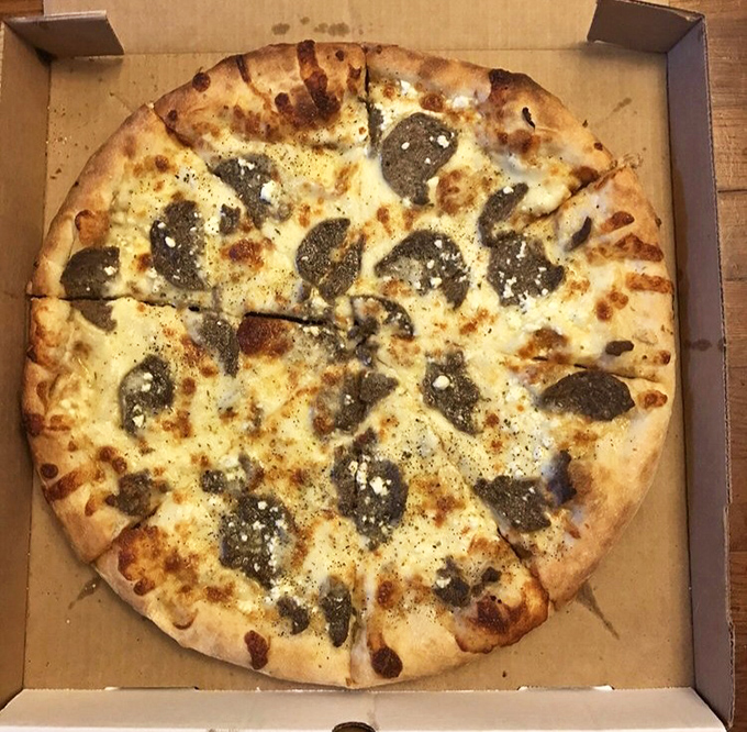 This white pizza with savory toppings proves that sometimes, the absence of red sauce creates the most profound pizza poetry. A beautiful blank canvas of cheese.