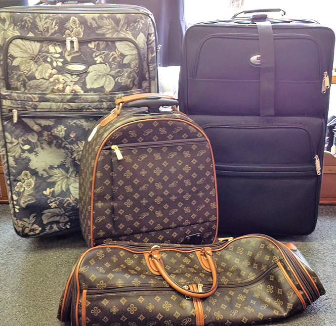 Designer lookalikes and vintage luggage stand ready for their next adventure. That floral piece has stories to tell!