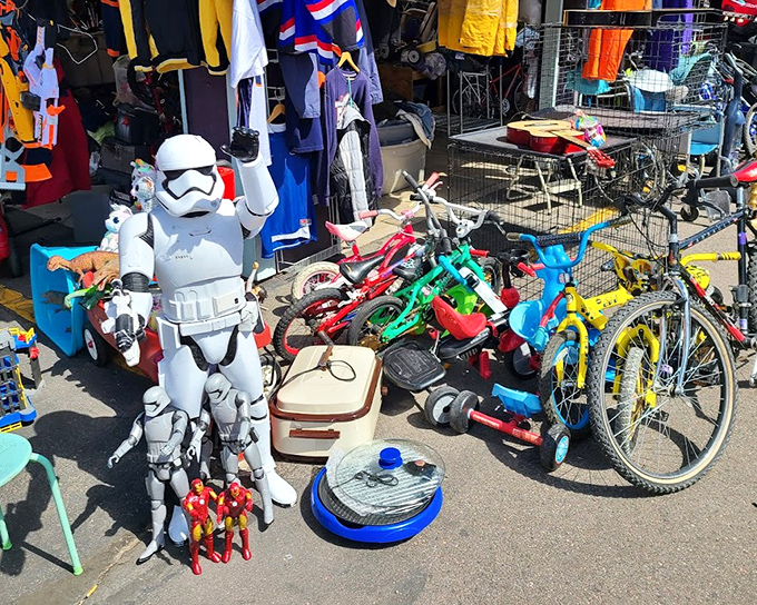 Where Star Wars meets yard sales! This eclectic display featuring a Stormtrooper standing guard over children's bikes proves that the Force is strong with flea market finds.