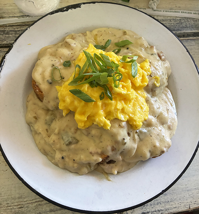 Biscuits and gravy nirvana! Fluffy scrambled eggs crown this masterpiece like a golden halo atop clouds of savory gravy goodness.