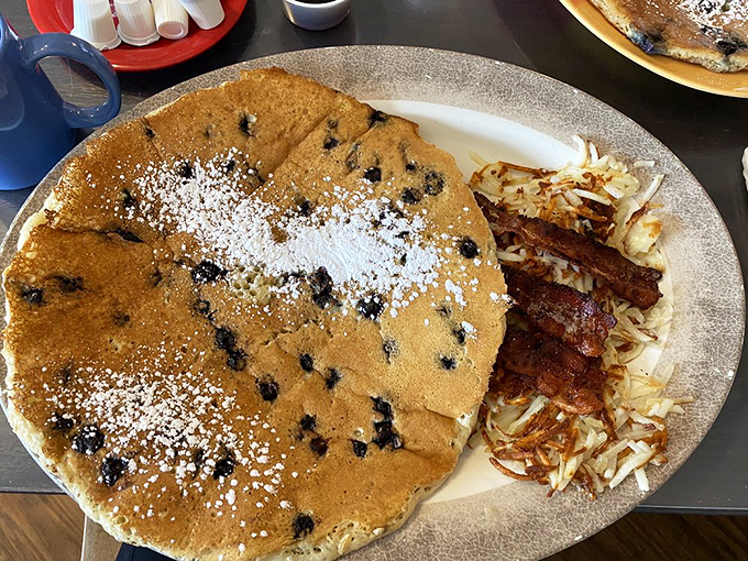 Behold the star of the show: fluffy pancakes dotted with berries like edible confetti.
