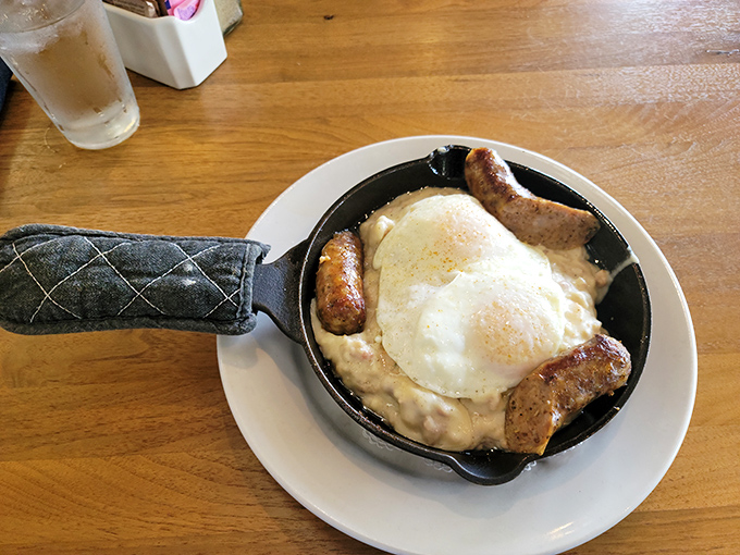 Breakfast sausage links cradling a sunny-side-up egg&mdash;like a warm, savory hug that says "good morning" better than words ever could.