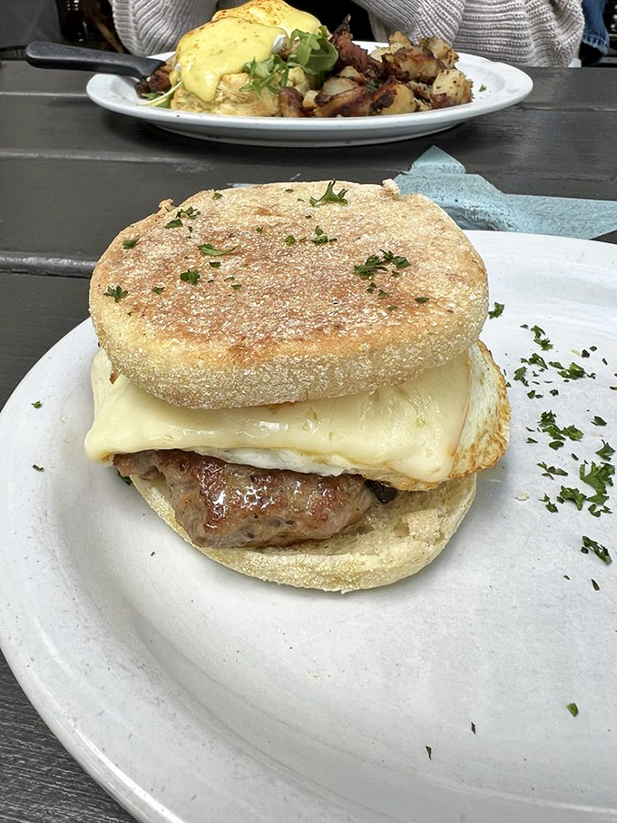 Breakfast sandwich perfection: a golden English muffin cradling a perfectly cooked egg and sausage patty. The morning handshake your stomach deserves.