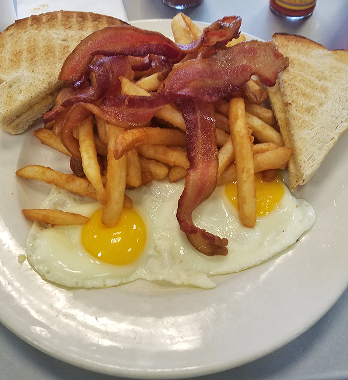 Behold the breakfast trinity: perfectly sunny-side-up eggs, crispy golden fries, and bacon that's achieved that magical state between chewy and crisp. 