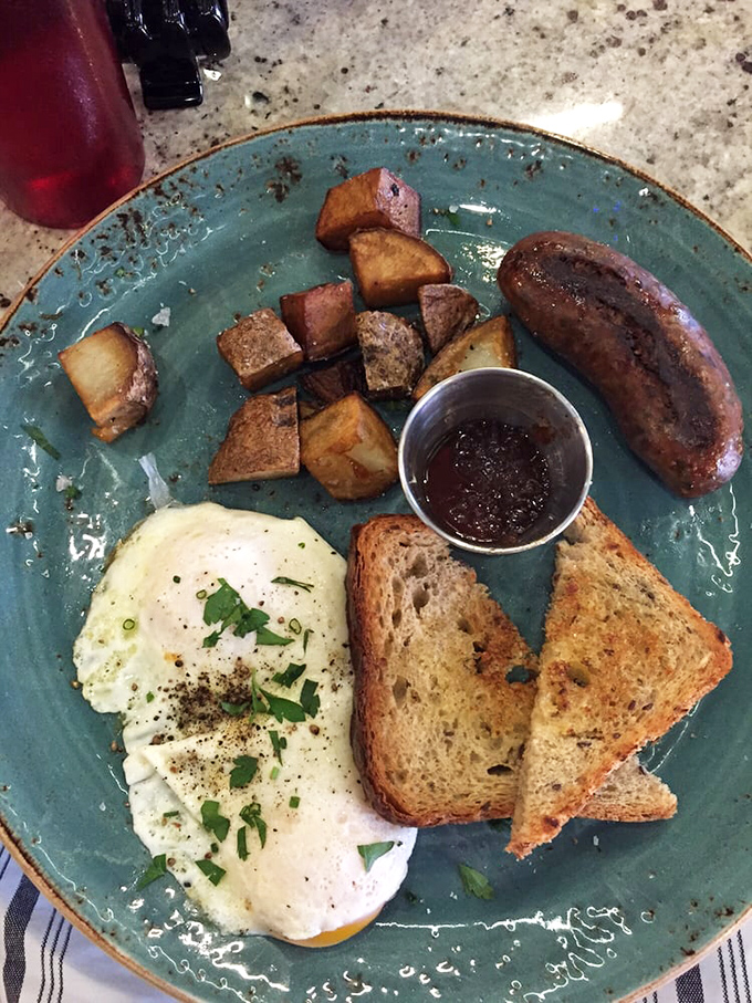 Breakfast perfection on a turquoise plate &ndash; the sunny egg, perfectly toasted bread, and those potatoes looking like they've achieved their highest purpose in life.