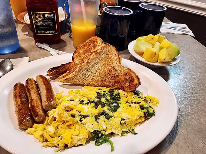 Spinach and eggs living their best life together on a plate, with sausage links playing the perfect supporting role.