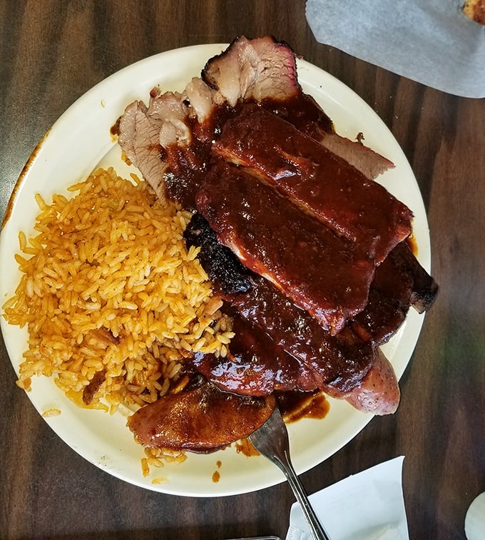 Behold the holy trinity: ribs, brisket, and sausage with Spanish rice. This plate has converted more vegetarians than a bacon shortage.