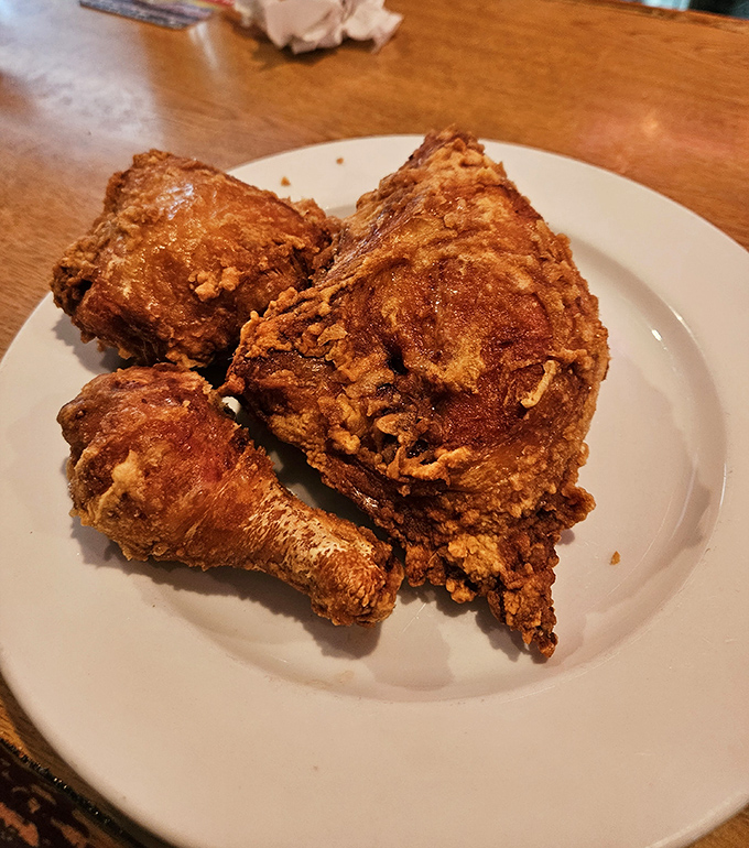 Behold the star of the show: broasted chicken with skin so crisp it practically shatters, revealing meat so juicy it should come with a warning label.