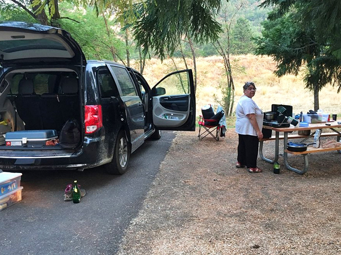 Home is where you park it. This shady campsite proves that "roughing it" can still include your favorite coffee mug and a proper breakfast setup.