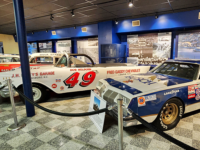 A tale of two eras. The vintage #49 racer shares space with its modern descendant, showing how NASCAR evolved while keeping its soul intact.