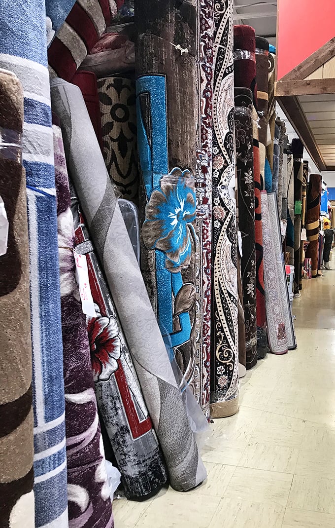 Rolled carpets standing at attention like textile soldiers, each pattern telling stories of homes they might transform and the footsteps they'll cushion.