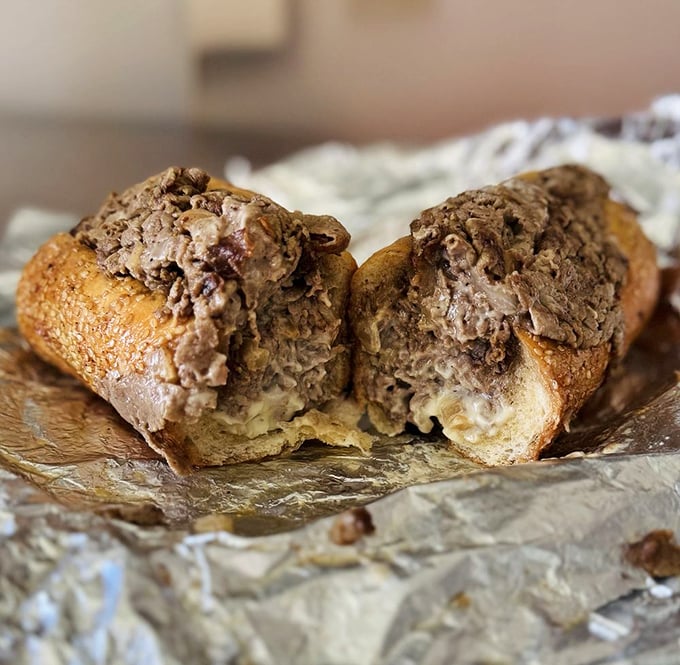 Behold the cross-section of perfection! The cheesesteak reveals its secrets: perfectly seasoned meat embracing melted cheese in a dance as old as Philadelphia itself.