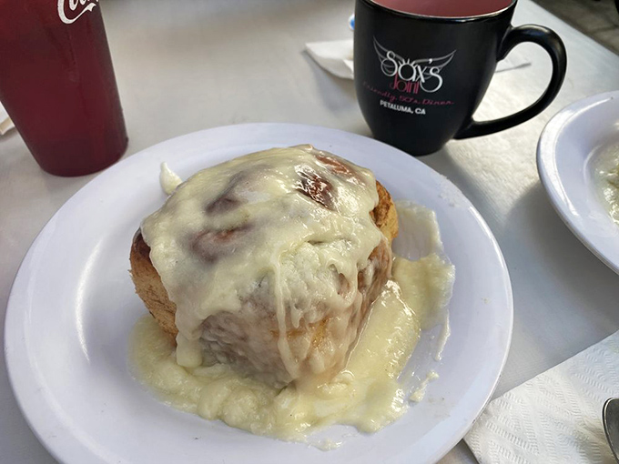 Behold the crown jewel: Mee Maw's Famous Cinnamon Roll, swimming in glorious icing. Diet plans have been known to spontaneously combust at first sight.
