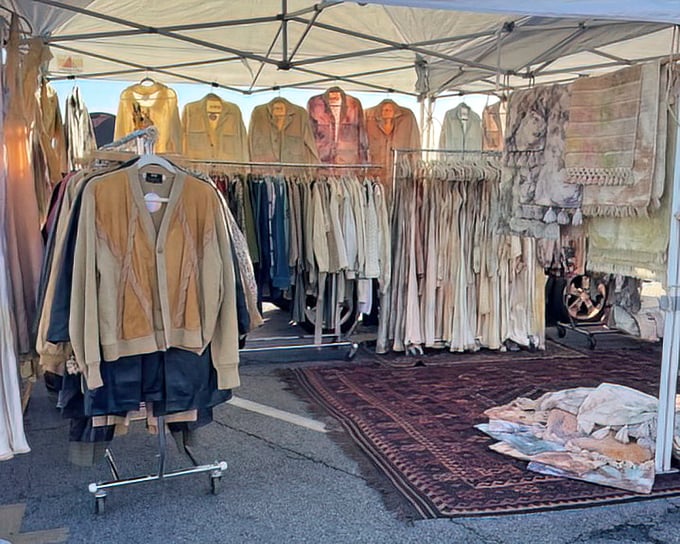 Vintage clothing nirvana. Suede jackets and delicate blouses await their second act, artfully displayed on a Persian rug stage.