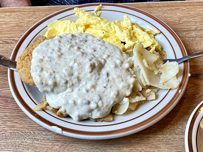 Behold the holy trinity of breakfast: country fried steak, eggs, and home fries swimming in peppery gravy. A plate that says "nap time" before you've taken your first bite.
