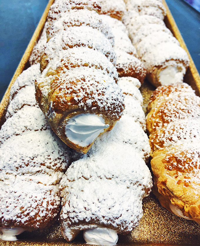These cream horns aren't just pastries, they're edible architecture &ndash; delicate layers of flaky dough dusted with powdered sugar, cradling clouds of fresh cream.