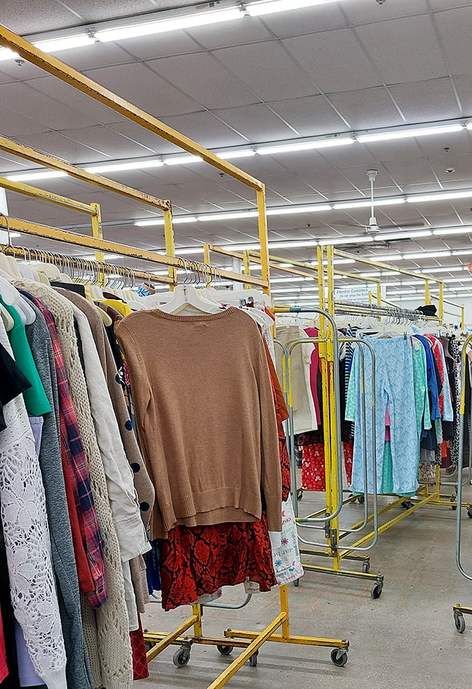 Yellow clothing racks stand like soldiers guarding fashion finds from every decade. That brown sweater might just be your next fall staple.
