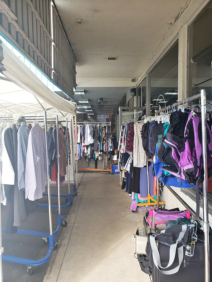 Racks of possibility line the walkway, each hanger a potential wardrobe revolution. The thrill of the hunt is real, folks.