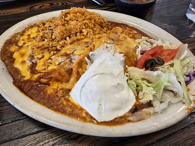 Behold the star attraction: enchiladas swimming in rich sauce, topped with melted cheese, and accompanied by perfectly seasoned rice. This isn't just dinner; it's edible artwork.