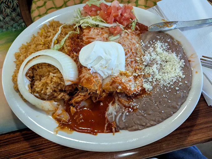 A plate that doesn't know the meaning of empty space. Rice, beans, shrimp, and that perfect white onion ring&mdash;a symphony of textures.