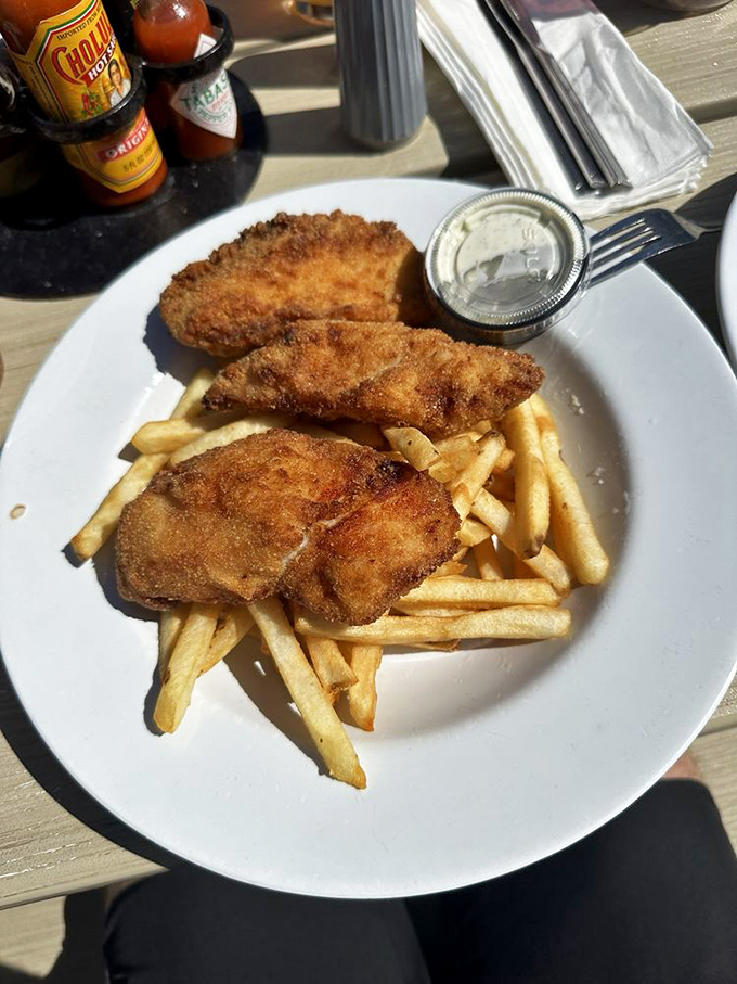 Golden-battered fish with a crunch that echoes across the bay, paired with fries that could make a Frenchman weep with joy.