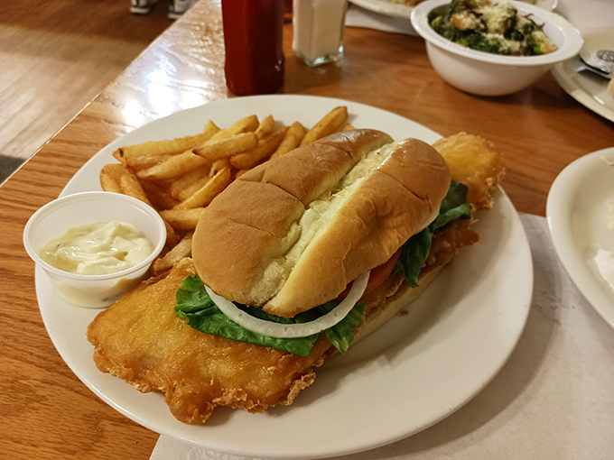 This fish sandwich isn't just a meal, it's an event – golden-fried perfection nestled in a soft bun with crispy fries standing guard.