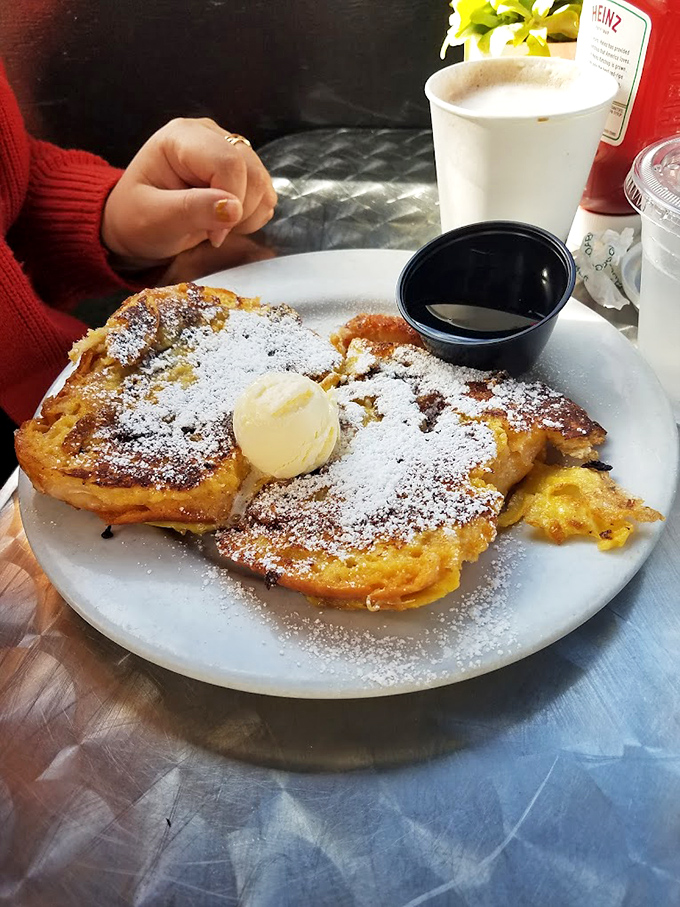 French toast that's achieved the impossible balance: crispy exterior, custardy interior, and enough powdered sugar to make your dentist wince approvingly.