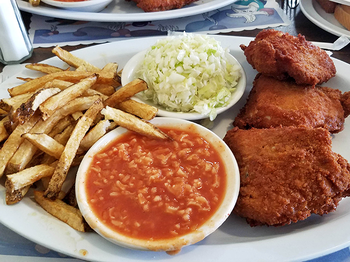 Behold the holy trinity of Barberton chicken: golden-fried perfection, that famous tomato rice "hot sauce," and hand-cut fries. This plate has launched a thousand road trips.