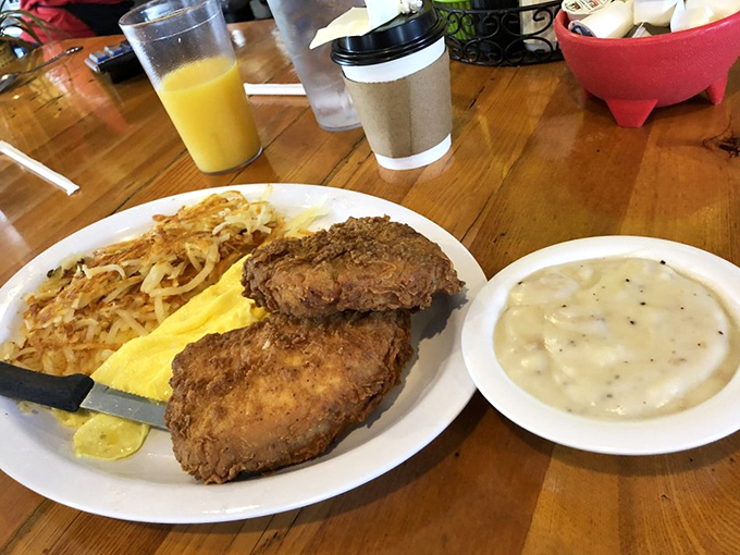 Crispy fried pork chops alongside golden eggs and hash browns &ndash; a plate that doesn't just say good morning, it shouts it with conviction.