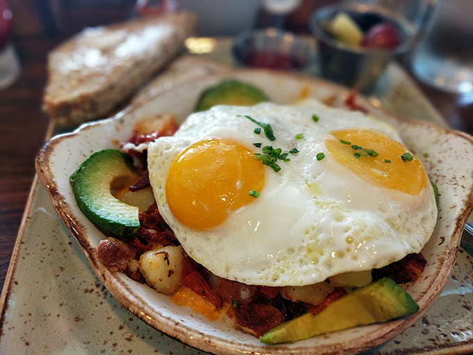 Sunny-side up eggs crown this hearty hash like royalty, while avocado slices add creamy richness that makes Monday mornings bearable again.