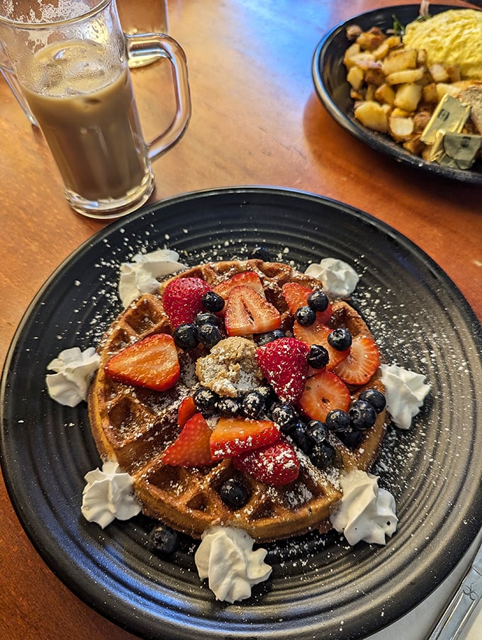 Fresh berries crown this waffle masterpiece like jewels on a golden throne of breakfast perfection.
