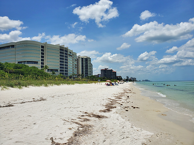 Civilization peeks through the palms, reminding you that real life exists somewhere beyond this stretch of paradise. Thankfully, not too close.