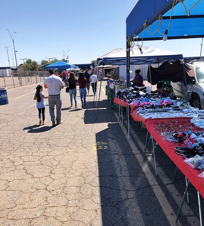 Families stroll through the outdoor marketplace, where red-clothed tables display everything from jewelry to toys. Weekend ritual meets retail therapy.