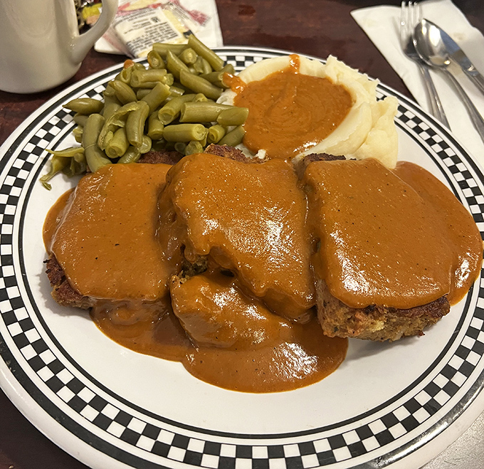 Meatloaf that would make your grandmother jealous, swimming in gravy that should have its own fan club. Paired with green beans for the illusion of virtue.