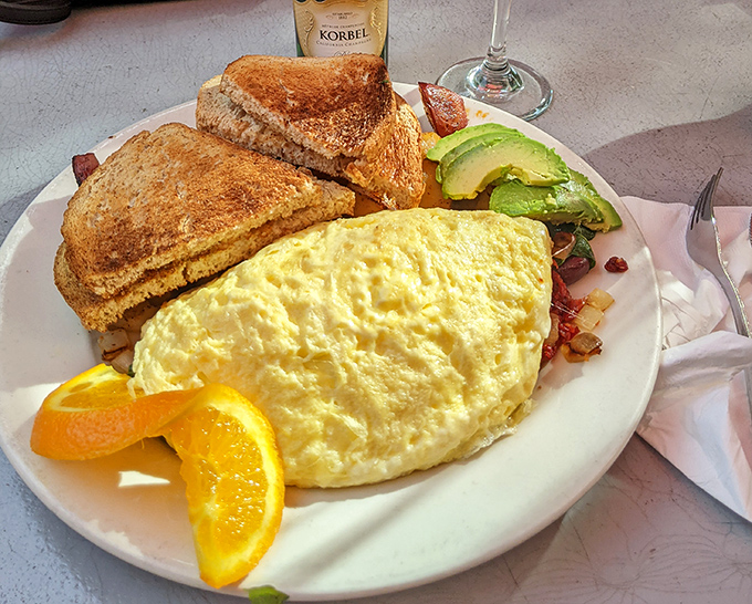 This omelet doesn't just sit on the plate&mdash;it lounges luxuriously, flanked by perfectly golden toast and avocado slices that California dreams are made of.